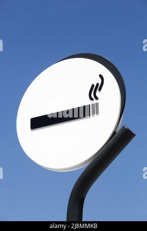 Outdoor designated smoking area with sign and ashtrays Stock Photo - Alamy