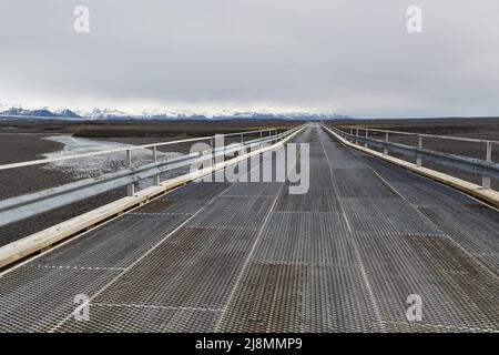 A car crossing the single lane steel bridge over the Clark Fork River ...