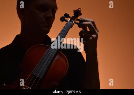 Violin being tuned by musician Stock Photo - Alamy