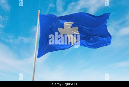 official flag of Rogaland , Norway at cloudy sky background on sunset ...