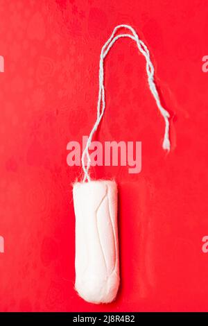 women's sanitary tampon on a red background, sanitary tampon made of ...