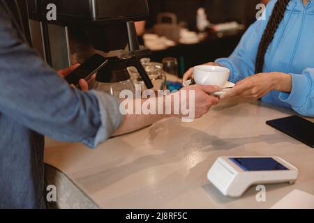 Man handing cup of tea to young woman sitting on bed Stock Photo - Alamy