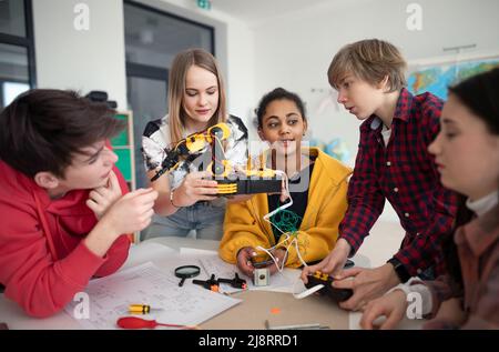 Group of students building and programming electric toys and robots at robotics classroom Stock ...