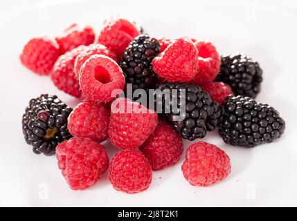 handful of raspberry and blackberry berries on white background Stock ...
