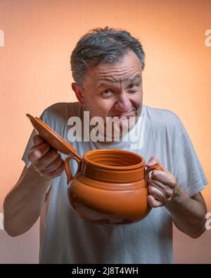 one old clay pot for cooking with closed cap isolated on white Stock ...