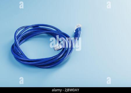 A coil of RJ45 Cat.6 Ethernet Network Internet Cable isolated on a blue ...