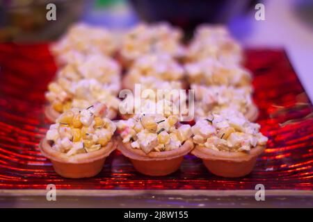Tartlets or mini tarts with corn and crab salad on red plate Stock ...