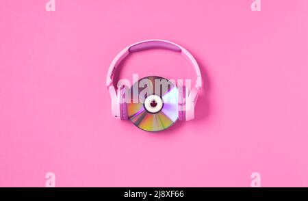 Pink youth headphones music cd discs on a pink background, flat lay ...