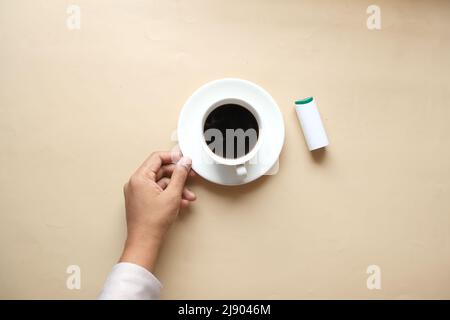 artificial sweetener container and tea cup on table Stock Photo - Alamy