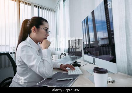 Asian female software developer is worried about analyzing code-based ...
