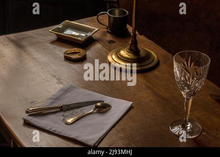Period still life table setting with picture frames and an old clock ...