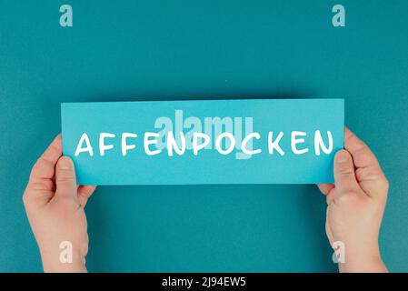 The word monkeypox is standing in german language on a paper, outbreak ...