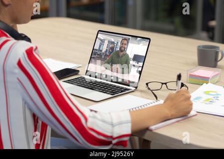 Smiling african american businessman video conferencing with female ...