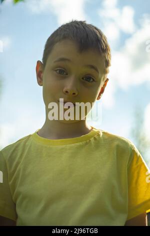 boy walking in a beautiful white suit against the background of nature ...