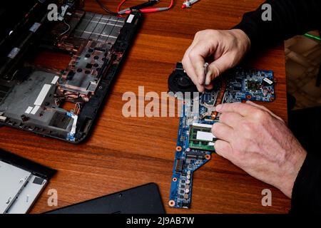 a computer repairman disassembles, repairs and does preventive ...