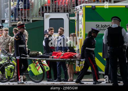 A member of the Irish Guards fainting under the high temperature today ...