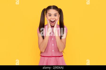 Shocked eye-popping tween girl show surprise yellow background, OMG ...