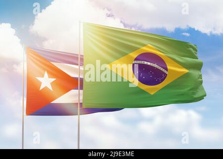Brazil and Cuba flags waving together on blue cloudy sky, two country ...