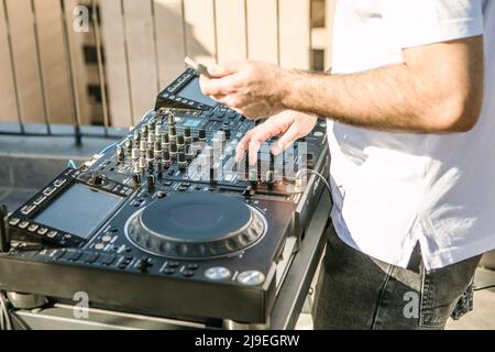 Close up view of a dj's hands playing the mixer while performing Stock ...