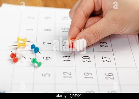 red Hand pin stuck on the day of the month in the calendar, business ...