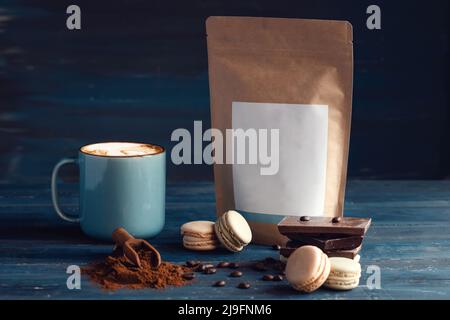 coffee beans, paper pack, macaroons and chocolate on wooden background ...