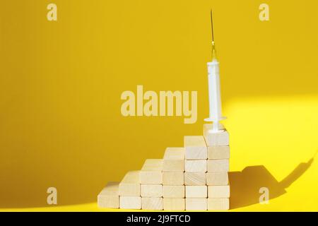 medical syringe on a ladder made of wooden sticks. drugs, vaccination ...