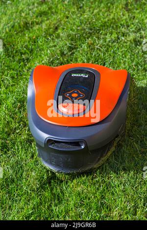 robotic Flymo lawnmower cutting grass lawn in May - compact robotic ...