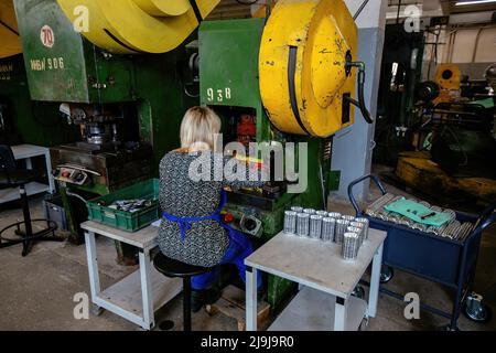 Worker operates metal press stamping machine. Production of press forms ...