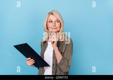 Photo of thoughtful minded lady hold avocado doughnut choose wear grey ...
