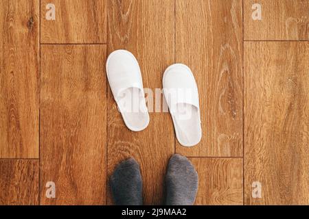 Male feet and disposable white slippers in hotel room, top view Stock ...
