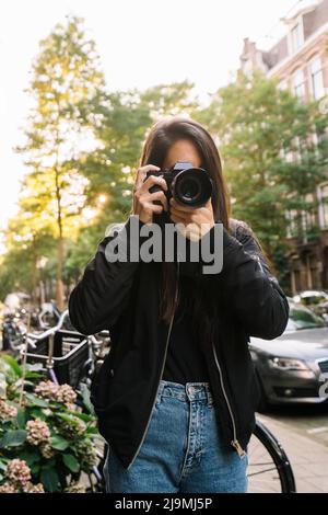 Stylish traveler standing near blurred tram on street in Prague,stock ...