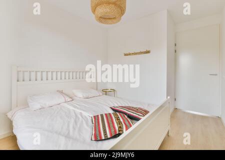 Comfortable bed with chrome glass bedside table located against window ...