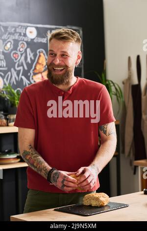 bearded man chef with bread in hand light background Stock Photo - Alamy