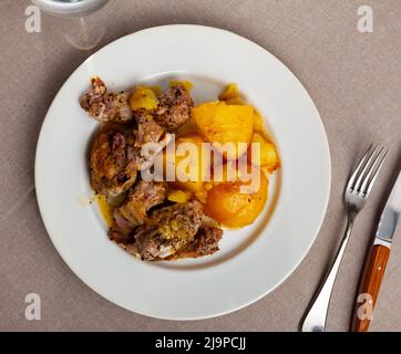 Braised rabbit served with potato garnish Stock Photo - Alamy