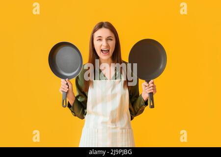 Beautiful angry woman with apron and frying pan Stock Photo - Alamy
