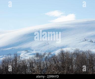 Scandinavian Mountains in March. Bright sunshine, thaw on the hillside ...