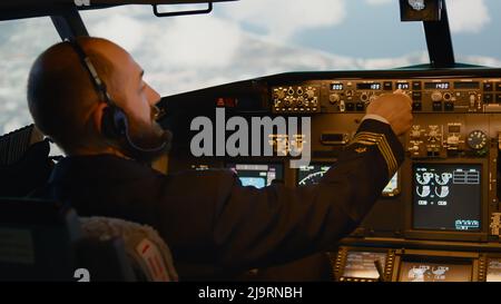 Pilot aviator fixing altitude and longitude level on dashboard in plane ...