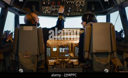 Pilot aviator fixing altitude and longitude level on dashboard in plane ...