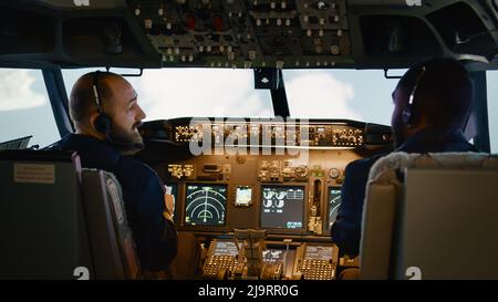Diverse team of captain and pilot pushing engine throttle lever to ...