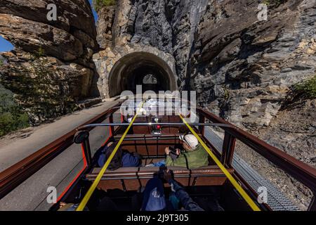 Iconic Red Jammer bus entering westside tunnel in Glacier National Park ...