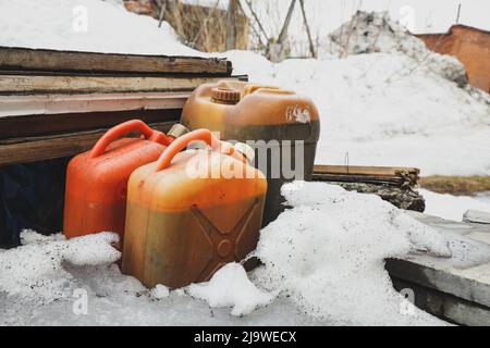 Old plastic canisters in the snow. Industrial background Stock Photo ...
