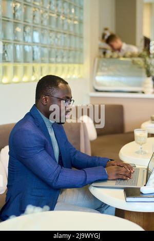 African businessman concentrating on his online work on mobile phone ...