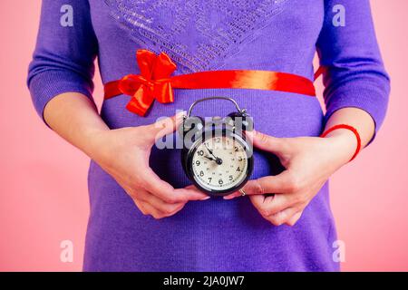 Hands of girl holding pink alarm clock Stock Photo - Alamy