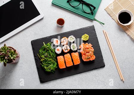 Sushi takeaway at work desk overhead. Eating sushi for lunch break ...