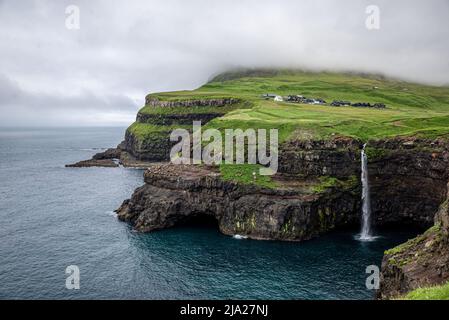 Mulafossur waterfall into the ocean behind Gásadalur Village, Vágar ...