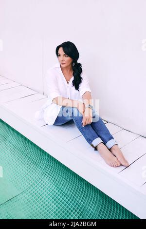 Outdoor spa lifestyle concept with woman using digital hot tub controls ...