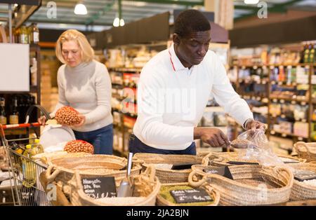 Man customer in supermarket search, choose product in fridge Stock ...