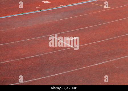 the red surface of the old running track at the stadium, the running ...