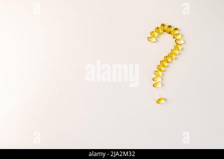 A question mark spelt out in vitamin d pills on a white background ...