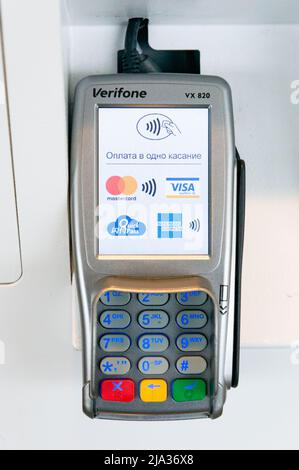 A closeup shot of the POS terminal credit card machine on a pink ...